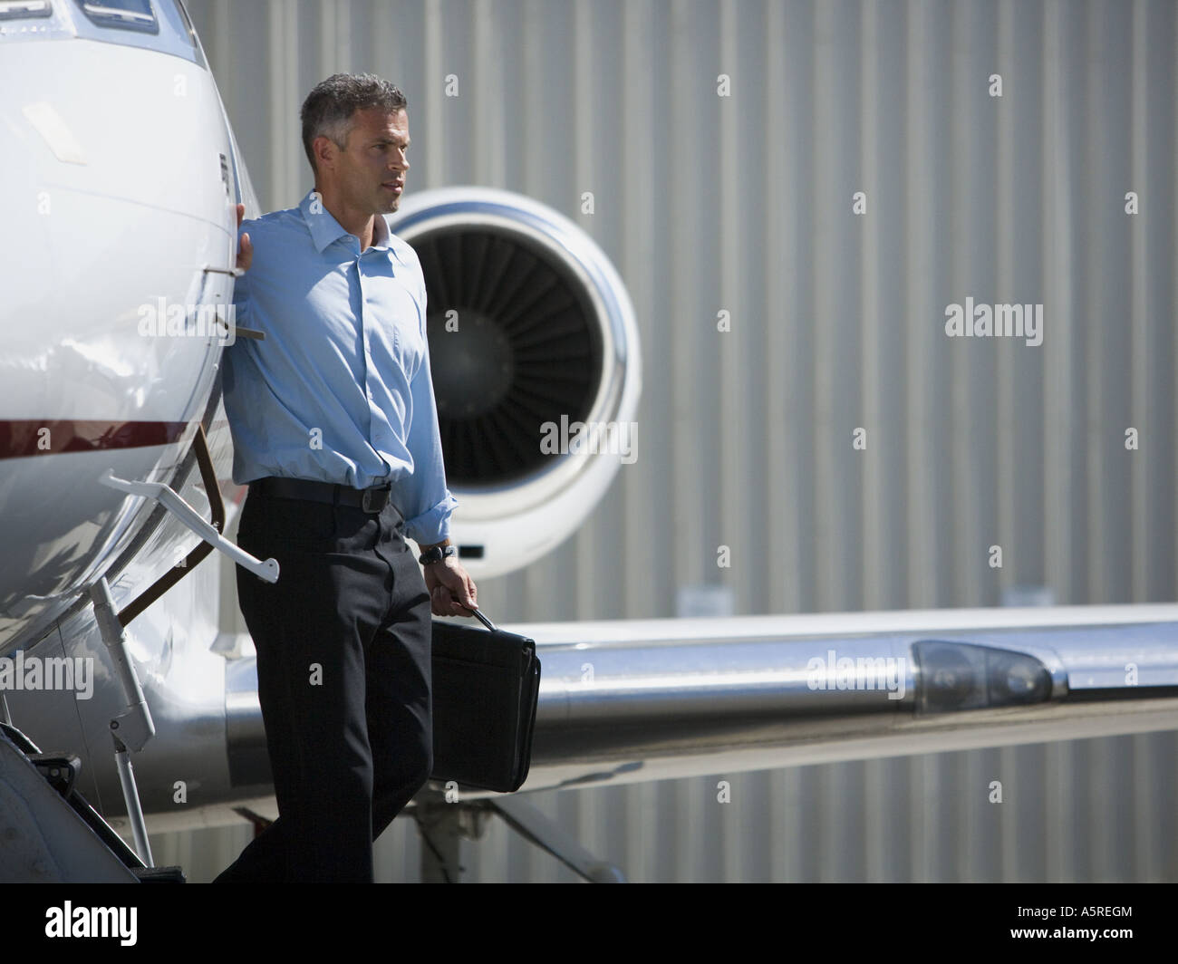 Profile of a businessman exiting an airplane Stock Photo - Alamy