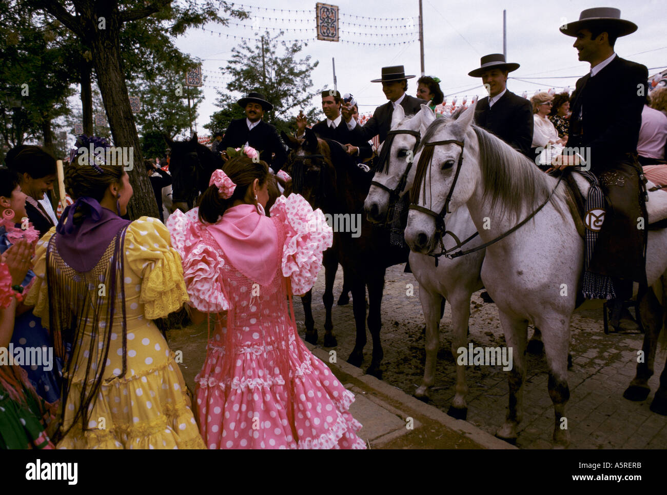 SEVILLE FAIR WOMEN STANDING AT THE SIDE OF THE ROAD WEARING FLAMENCO ...