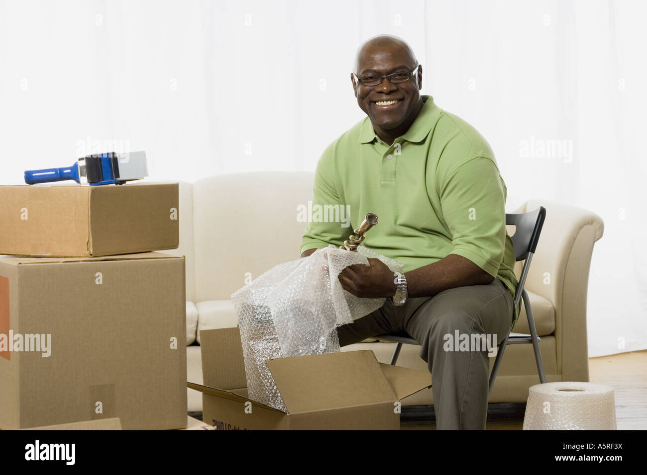 Portrait of a senior man packing up a lamp Stock Photo - Alamy