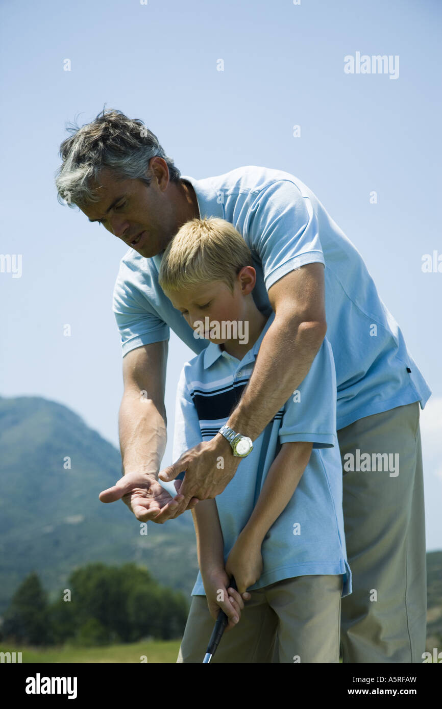 Father teaching his son to play golf Stock Photo - Alamy