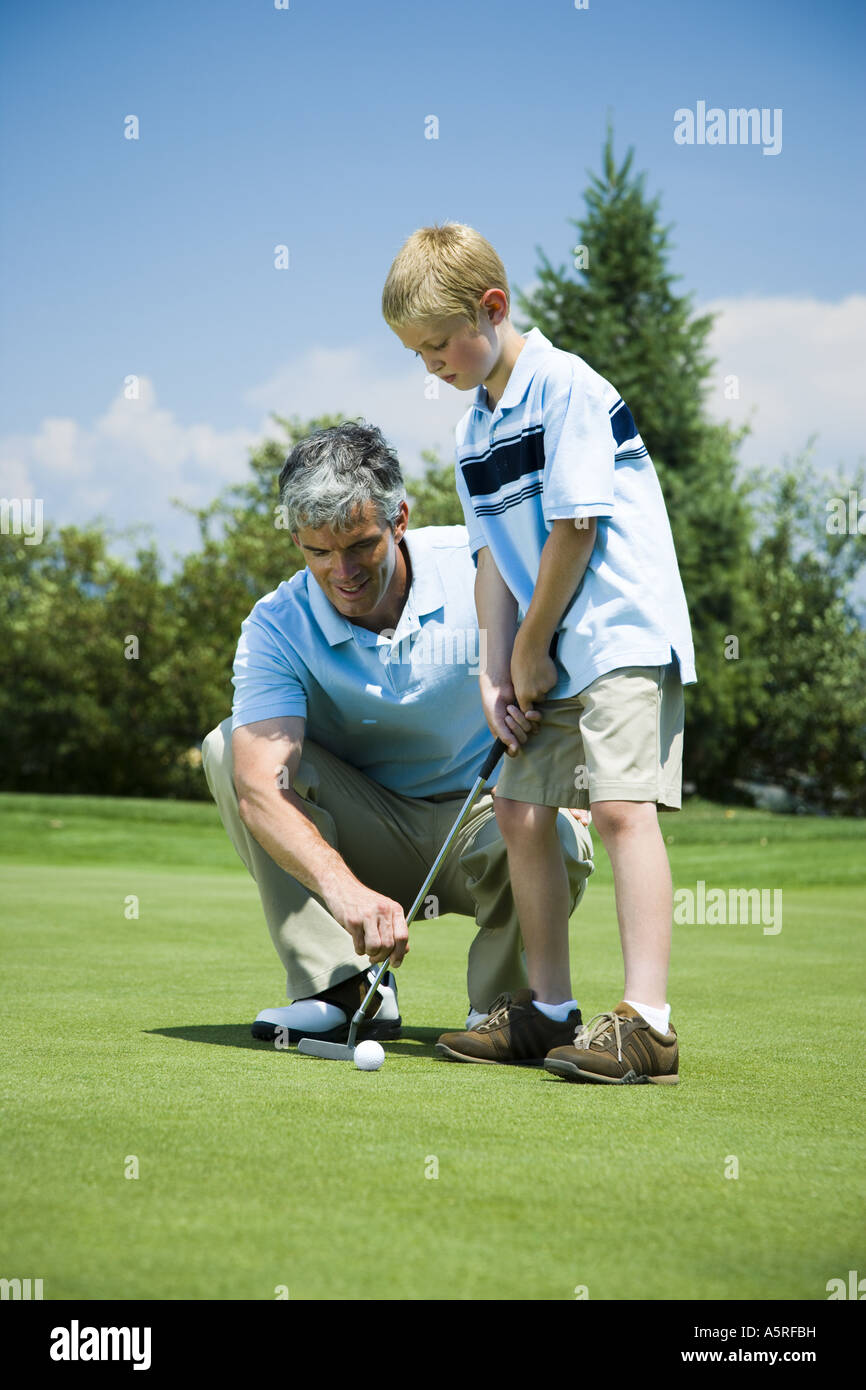 Father teaching his son to play golf Stock Photo - Alamy