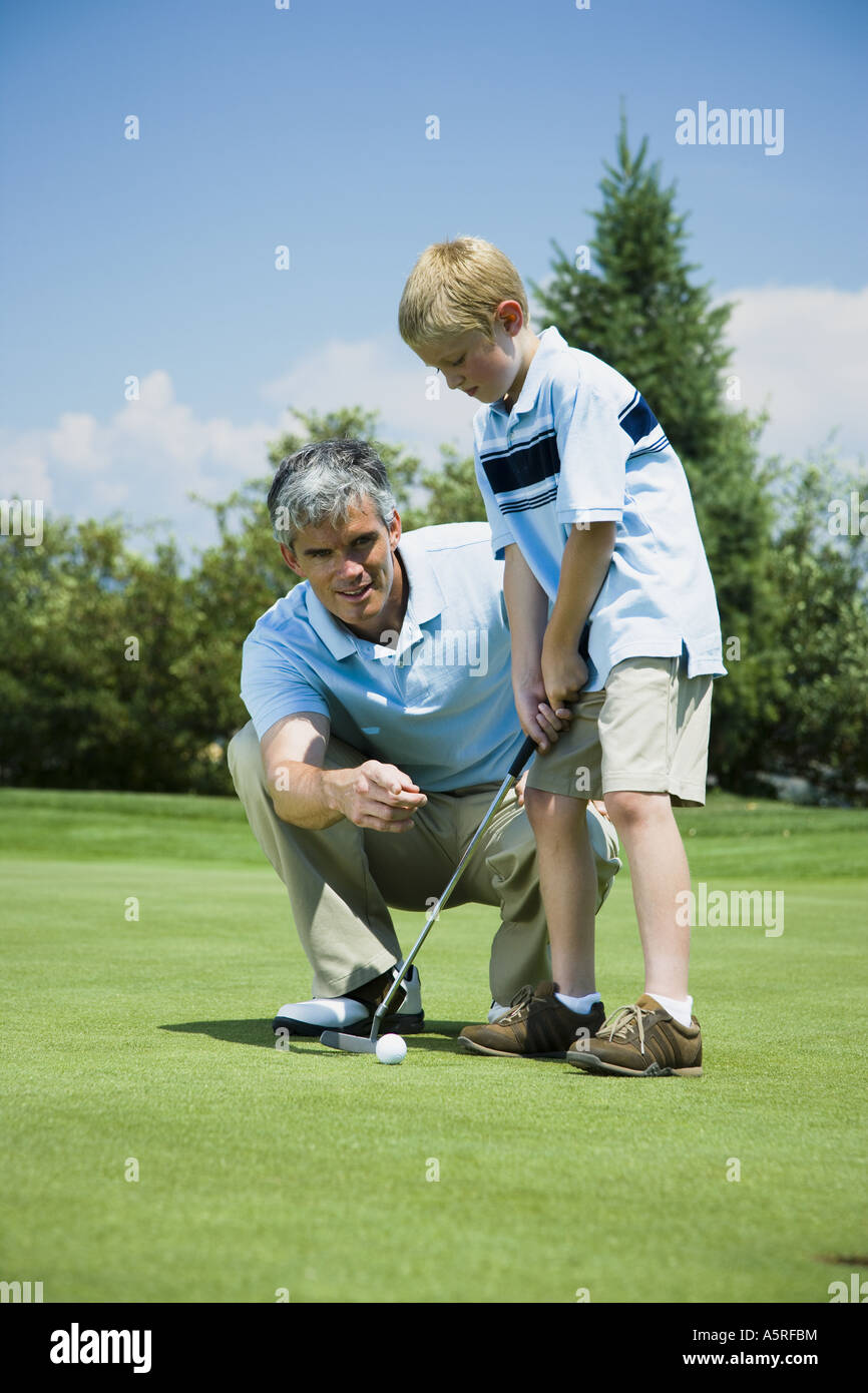 Father teaching his son to play golf Stock Photo - Alamy