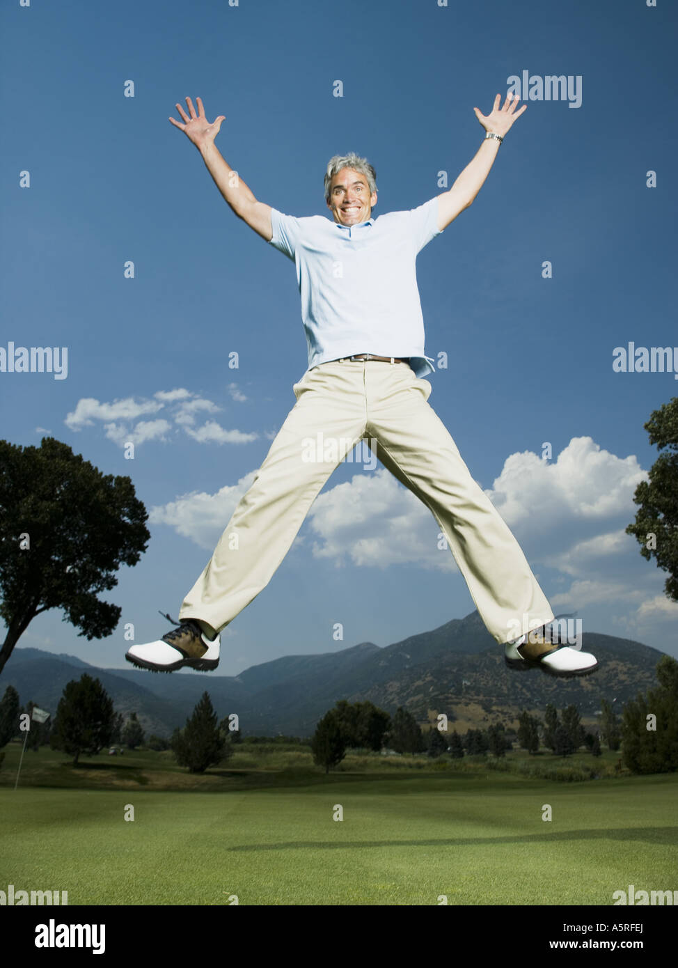 Portrait of a man jumping with his arms raised Stock Photo - Alamy