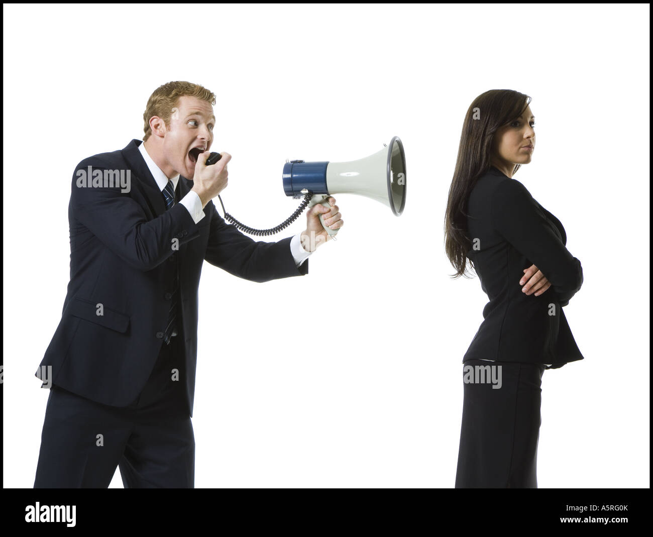 Profile of a businessman shouting into a megaphone with a teenage girl ...