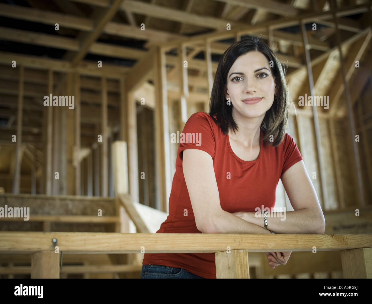 Portrait of a young woman leaning against a railing Stock Photo - Alamy