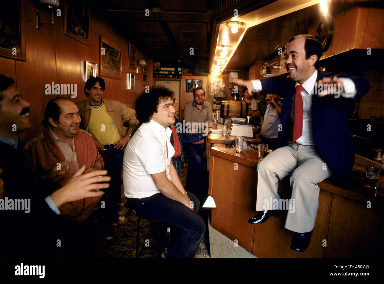 GUILLERMO WEARING A FINE SUIT SITS ON A MADRID BAR COUNTER ENTERTAINING ...