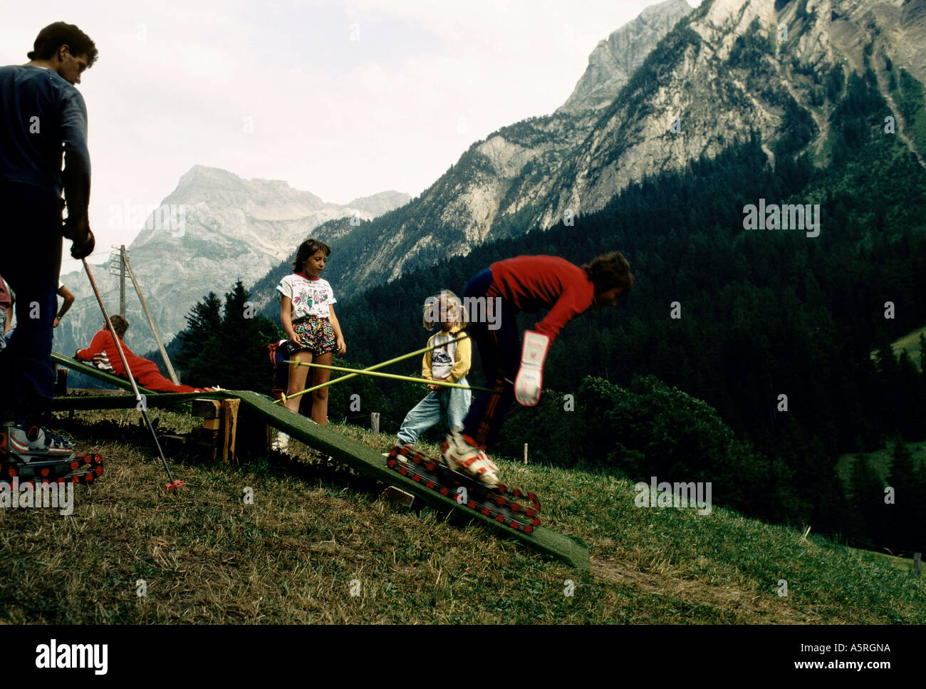 POLLUTION IN THE ALPS. CHILDREN PRACTISING GRASS SKIING NEAR GSTEIG ...