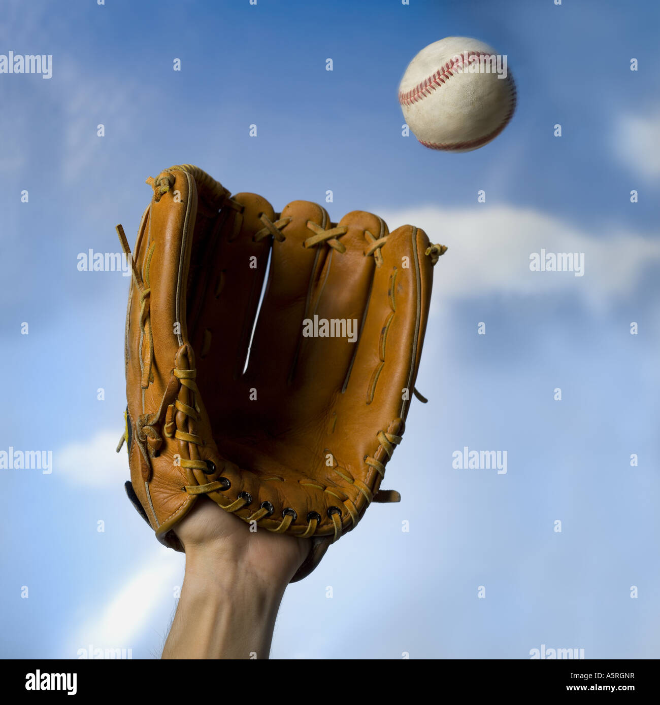 Low angle view of a person s hand catching a baseball with a baseball ...