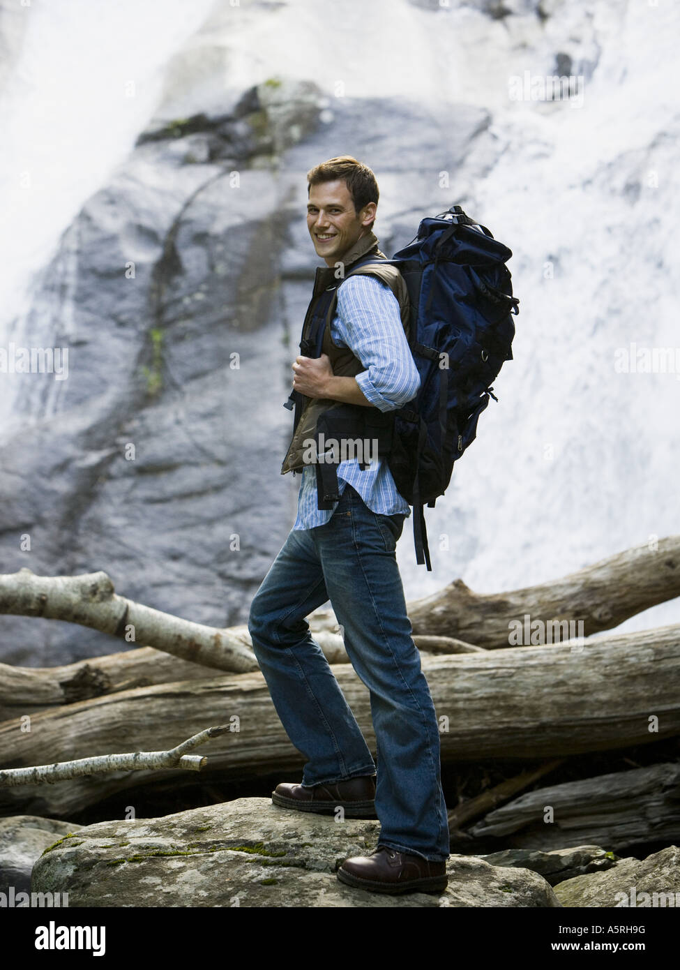 Portrait of a young man carrying a backpack Stock Photo - Alamy