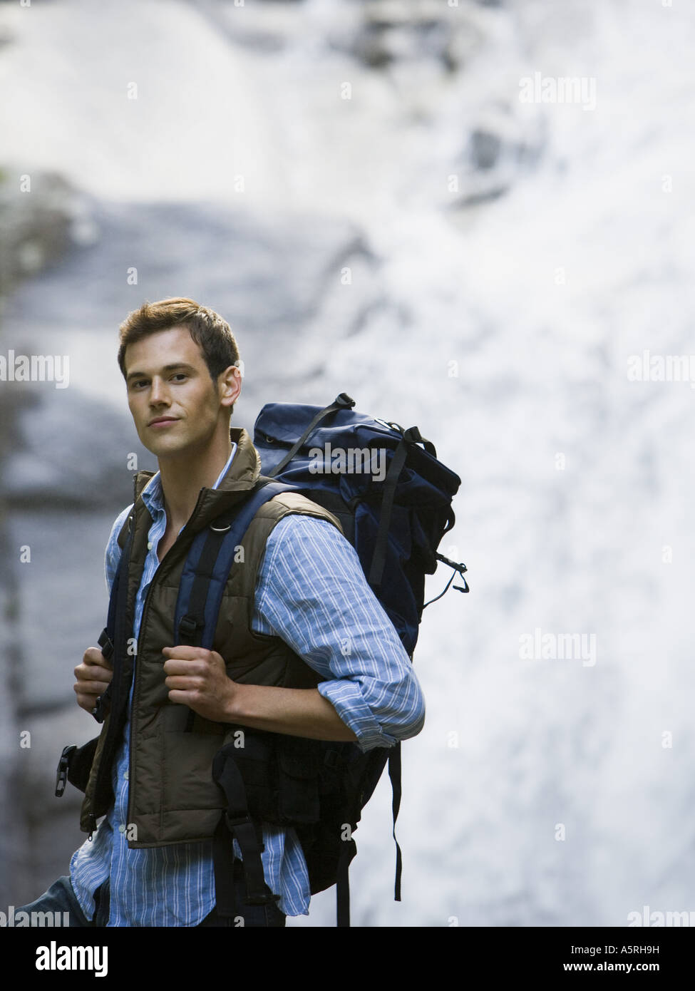 Portrait of a young man carrying a backpack Stock Photo - Alamy