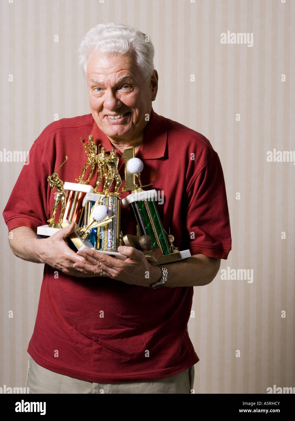 Portrait of a senior man holding trophies Stock Photo - Alamy