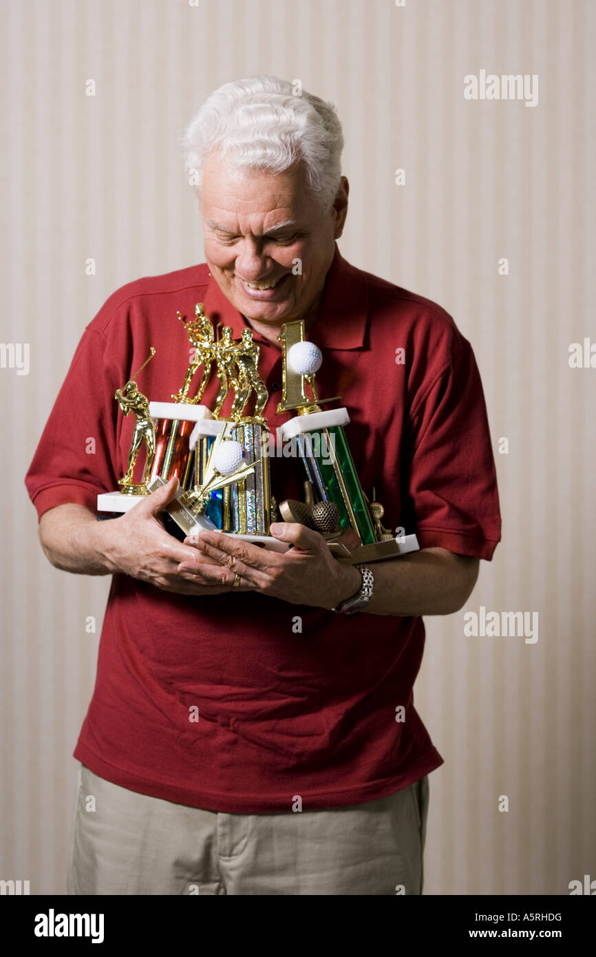 Portrait of a senior man holding trophies Stock Photo - Alamy