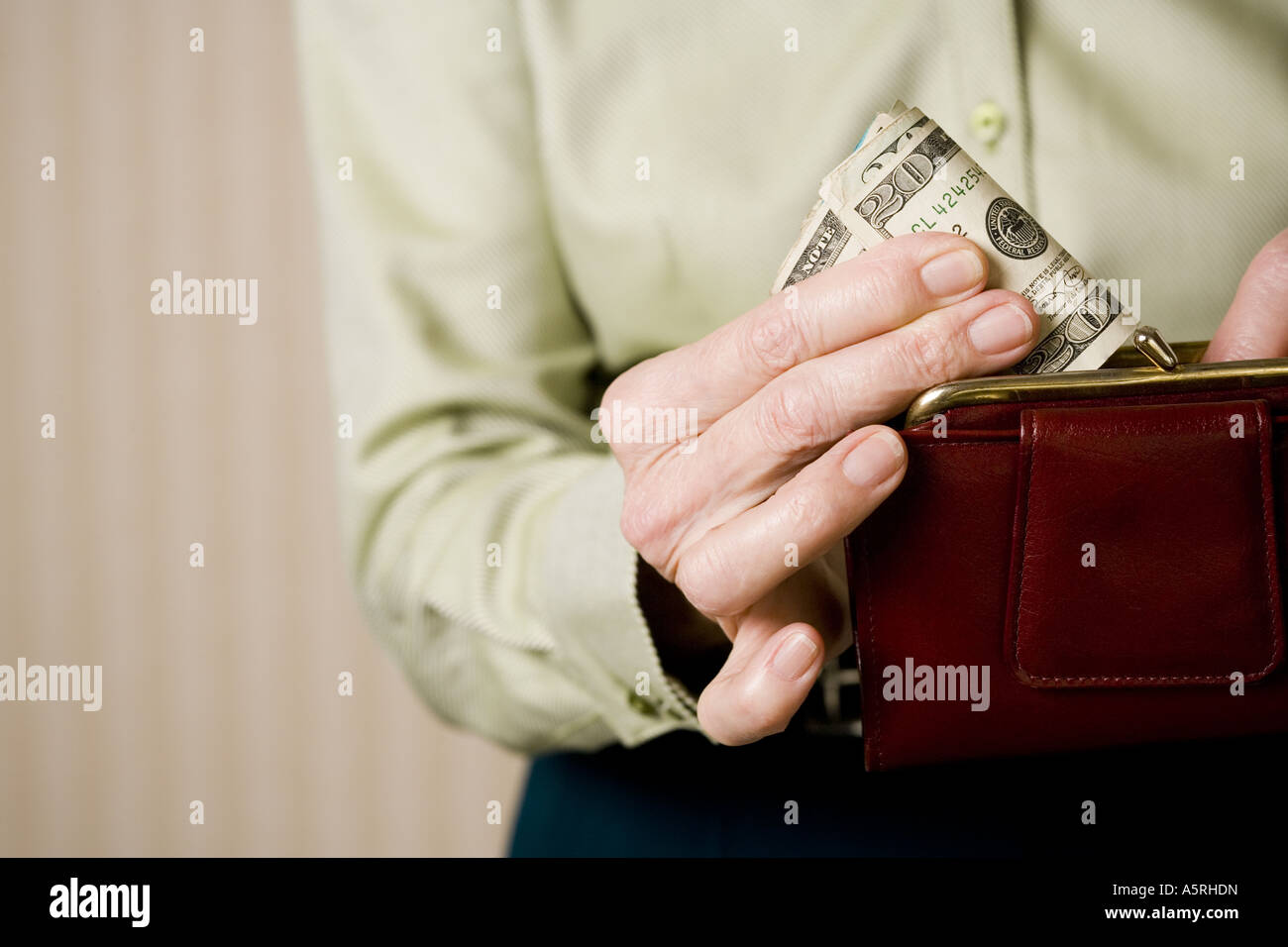 Mid section view of a woman keeping paper currency in a purse Stock ...