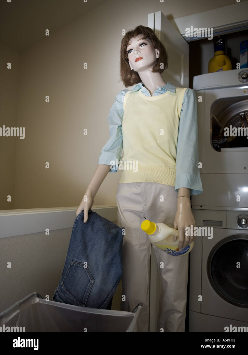 Female mannequin standing beside a washing machine and holding a pair ...