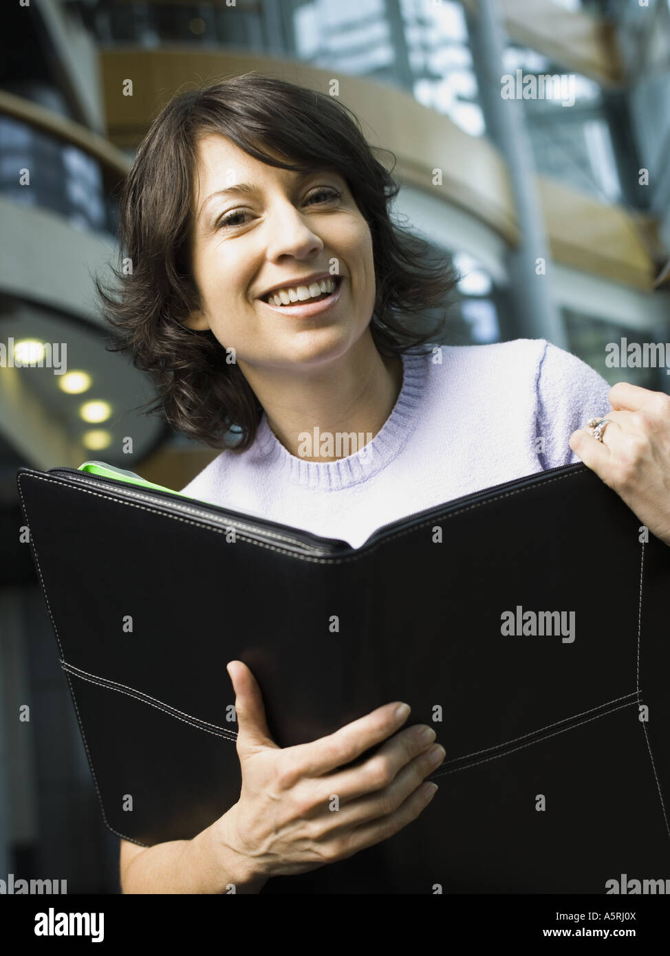Portrait of a woman holding a file Stock Photo - Alamy