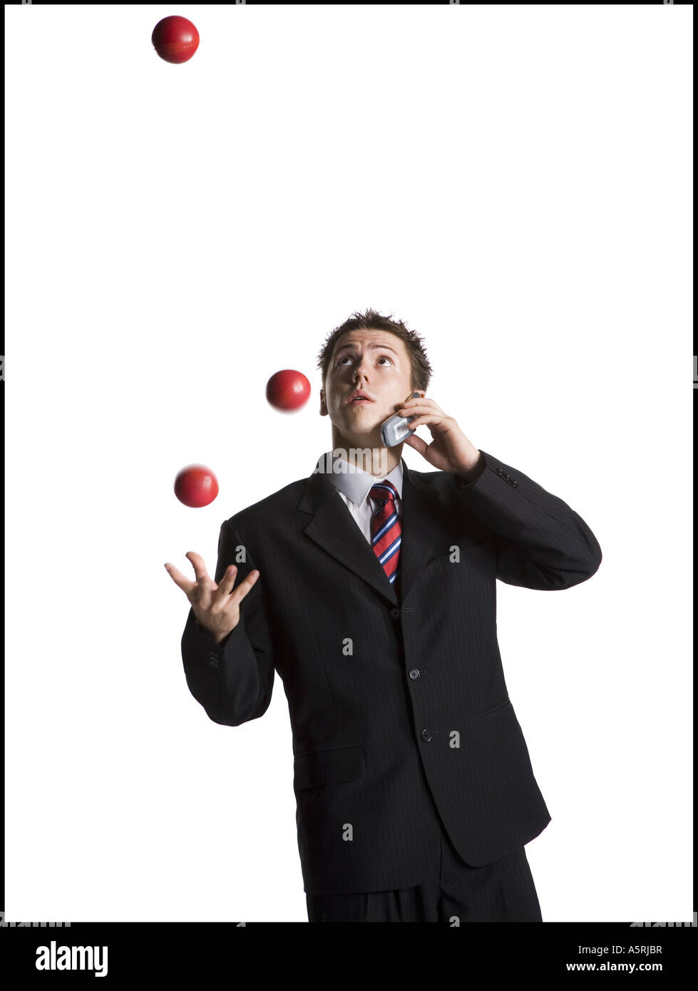 Businessman juggling while talking on phone Stock Photo - Alamy