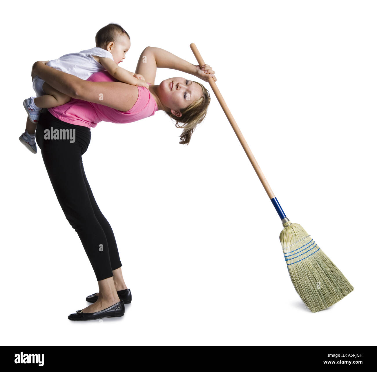 Contortionist mother sweeping while holding baby daughter Stock Photo ...