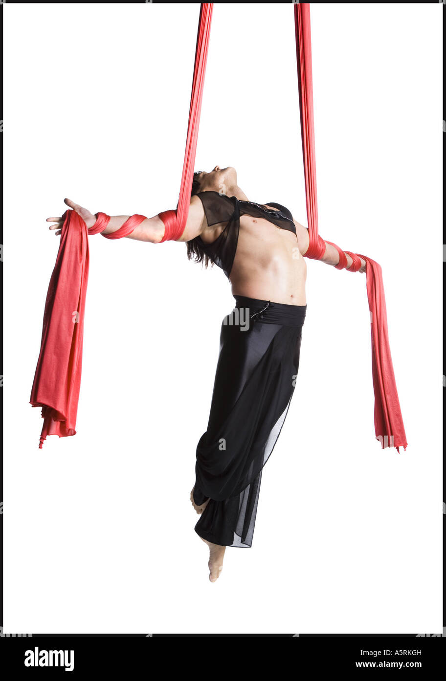 Male circus gymnast tangled in red drapes Stock Photo - Alamy