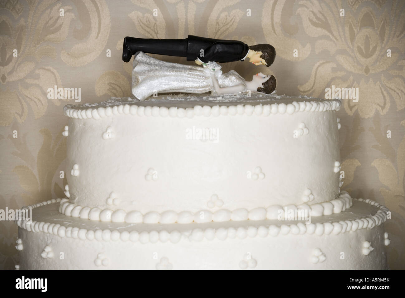 Wedding cake visual metaphor with figurine cake toppers Stock Photo - Alamy