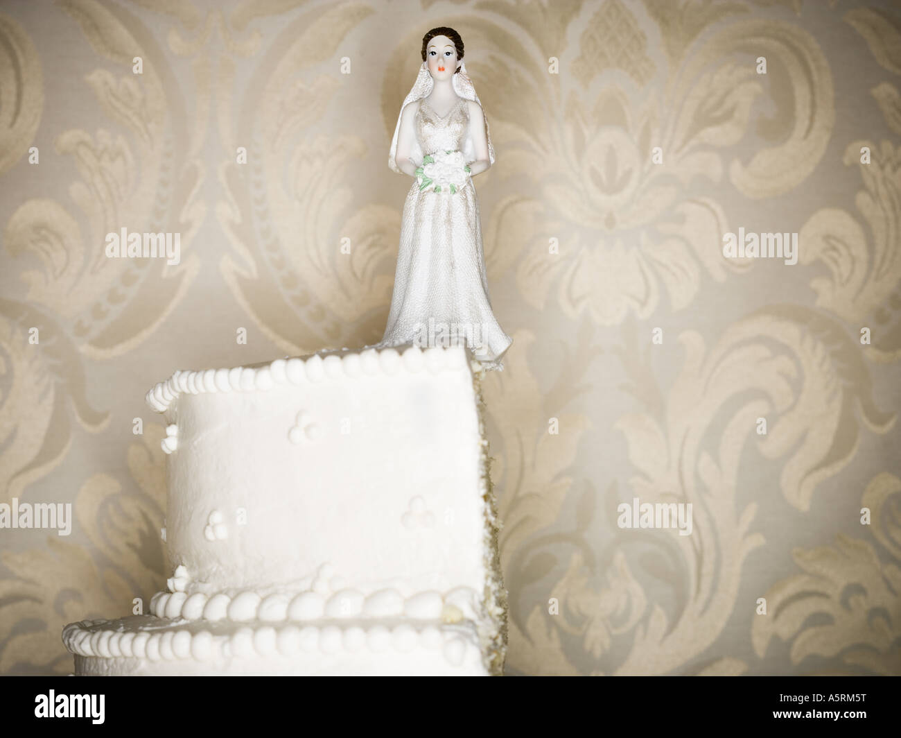 Wedding cake visual metaphor with figurine cake toppers Stock Photo - Alamy