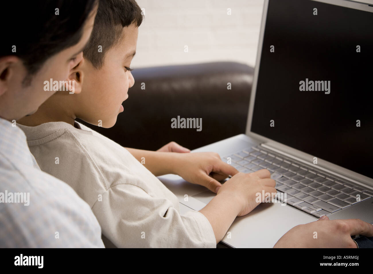 Father and young son working on laptop computer Stock Photo - Alamy