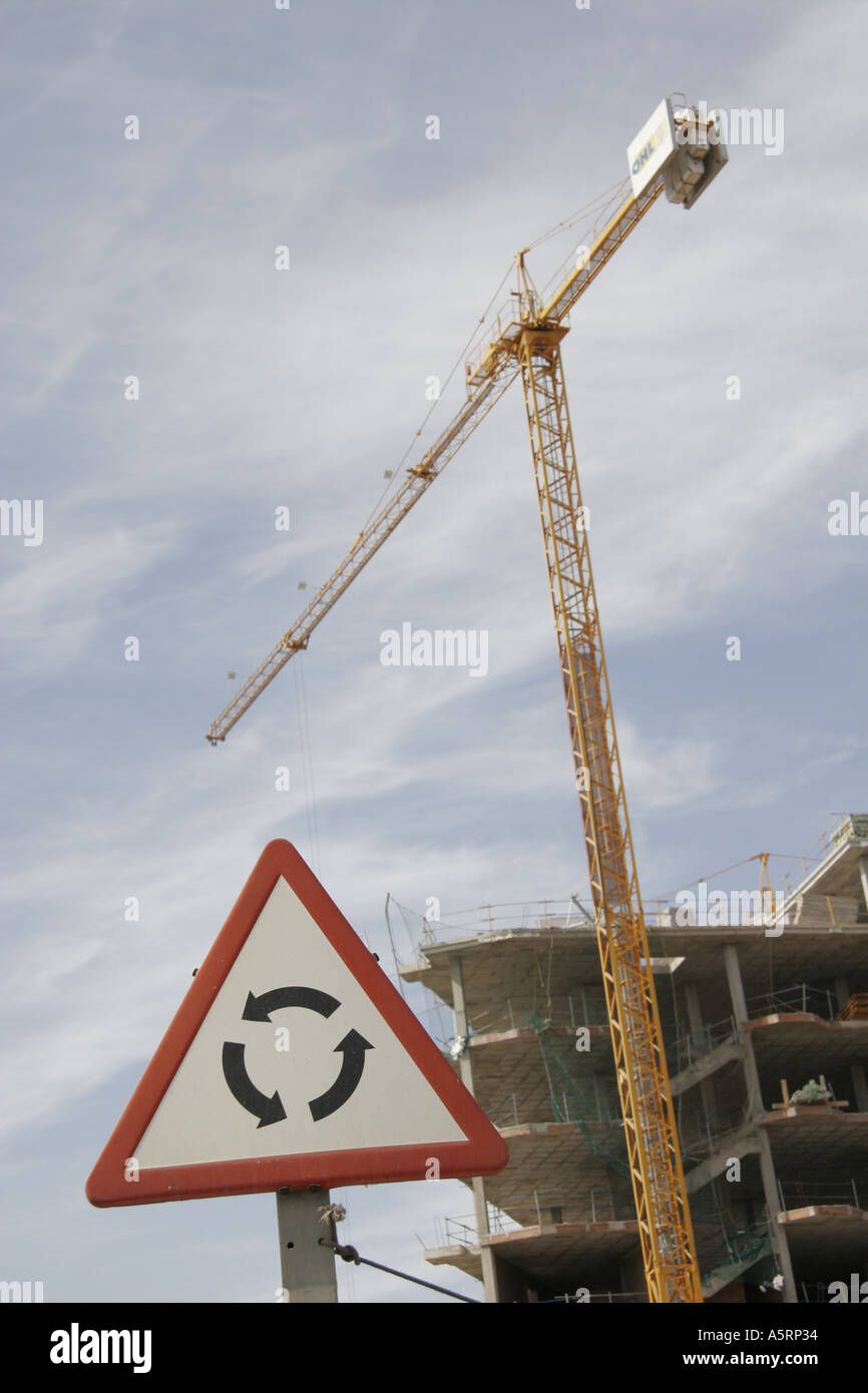 Crane Apartment building under construction and roundabout traffic sign ...