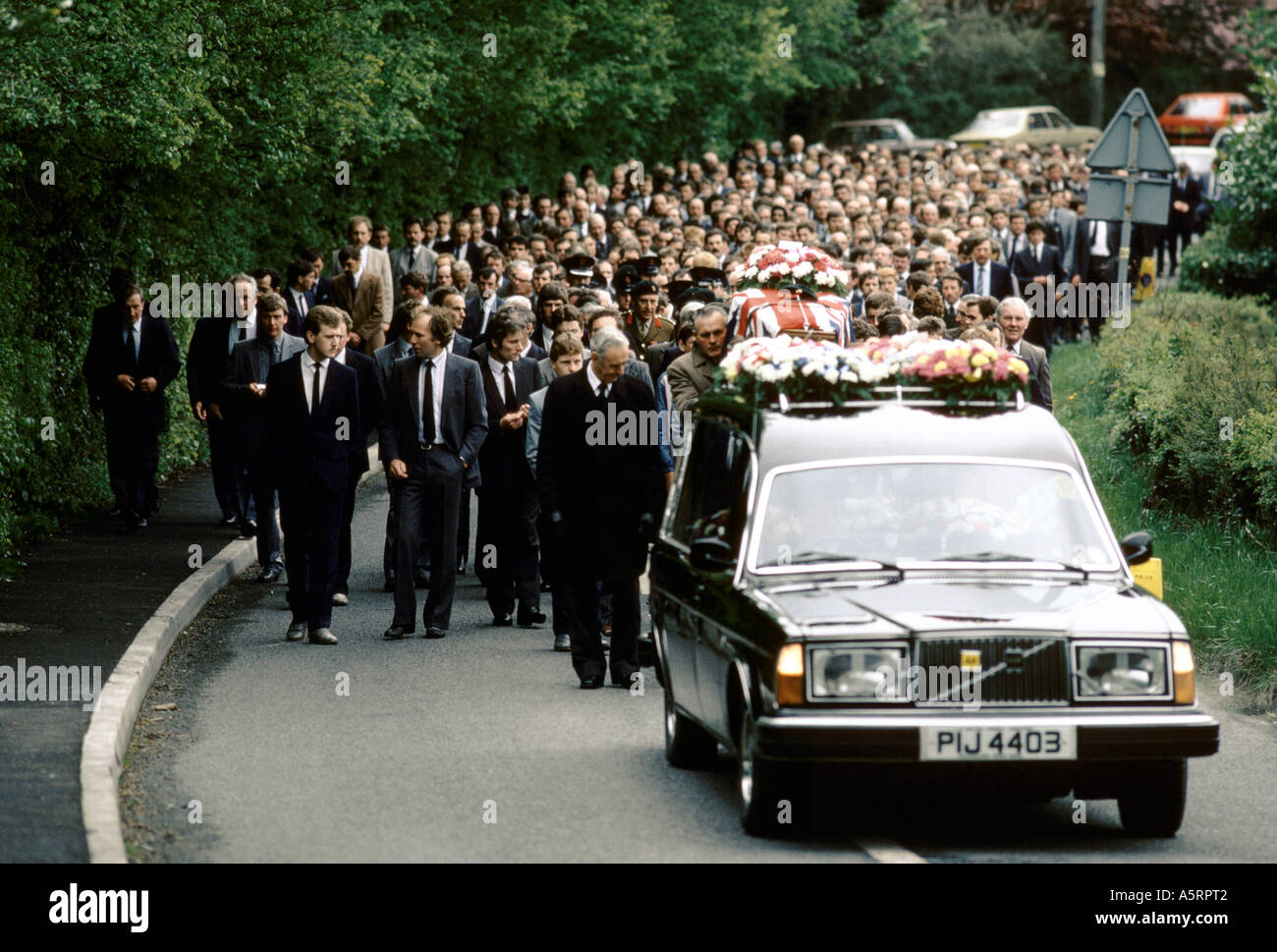 CORTEGE FOLLOWING MEN BEARING THE COFFIN WALKING ALONG ROAD BEHIND THE ...