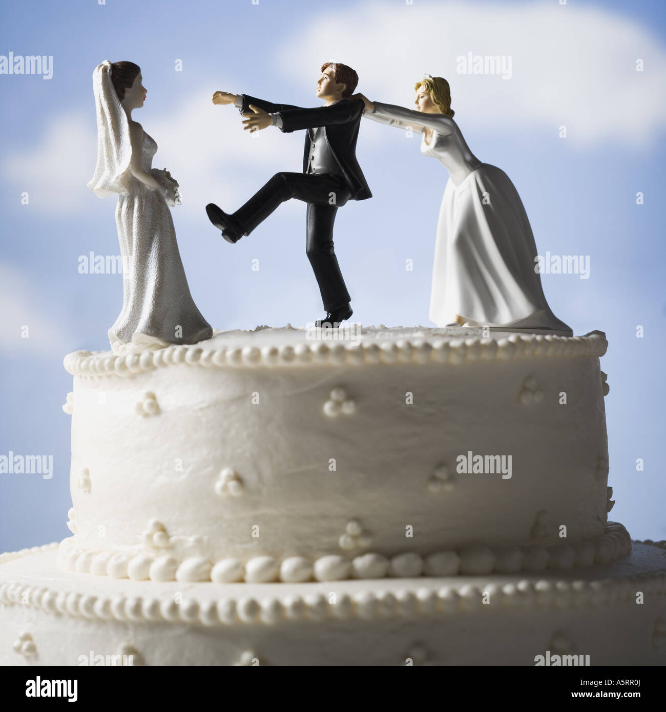 Wedding cake visual metaphor with figurine cake toppers Stock Photo - Alamy