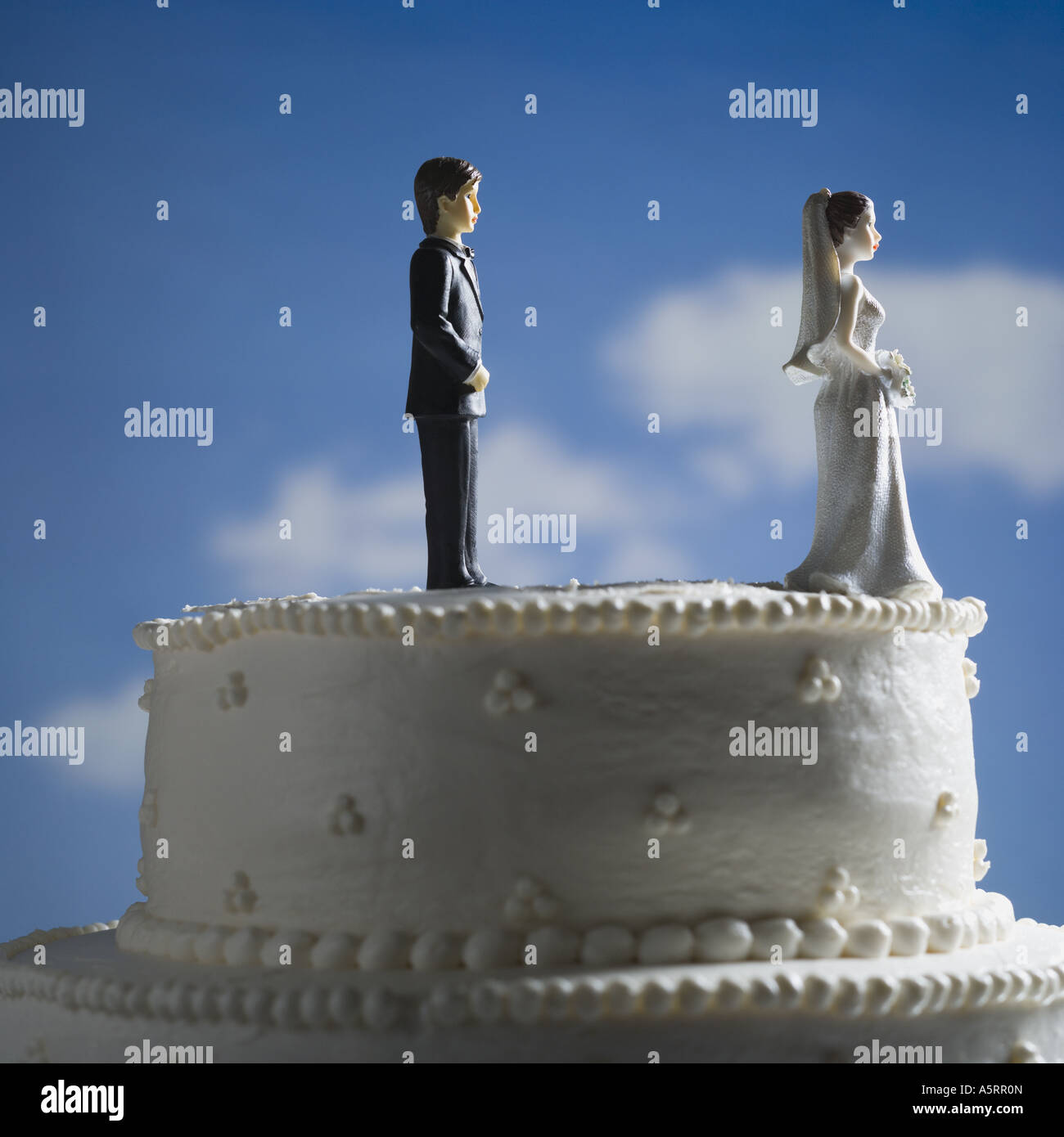 Wedding cake visual metaphor with figurine cake toppers Stock Photo - Alamy