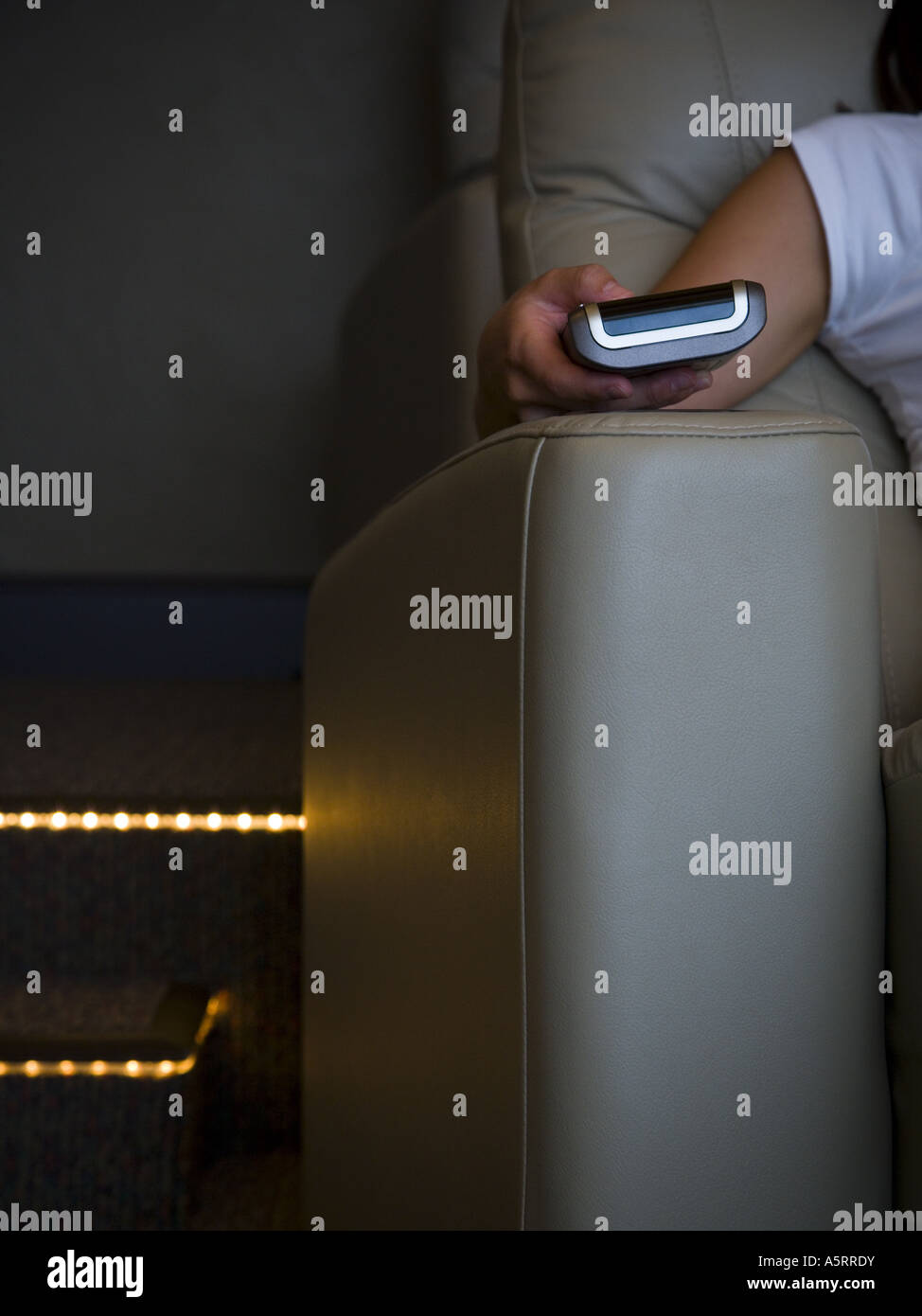 Hand holding remote control in home theater Stock Photo - Alamy