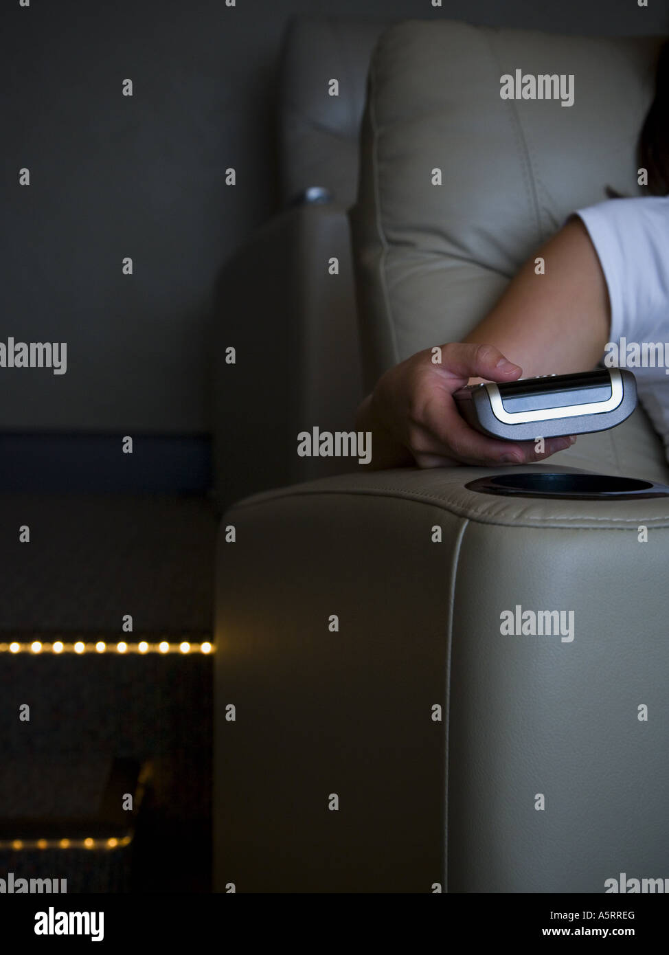 Hand holding remote control in home theater Stock Photo - Alamy