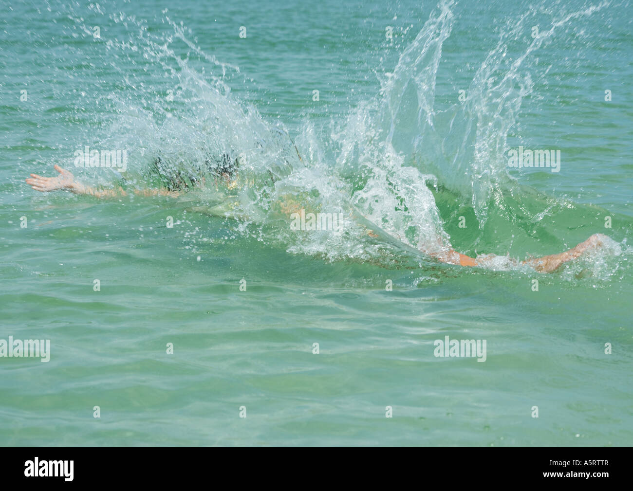 Splash in sea after person falls back into water Stock Photo - Alamy