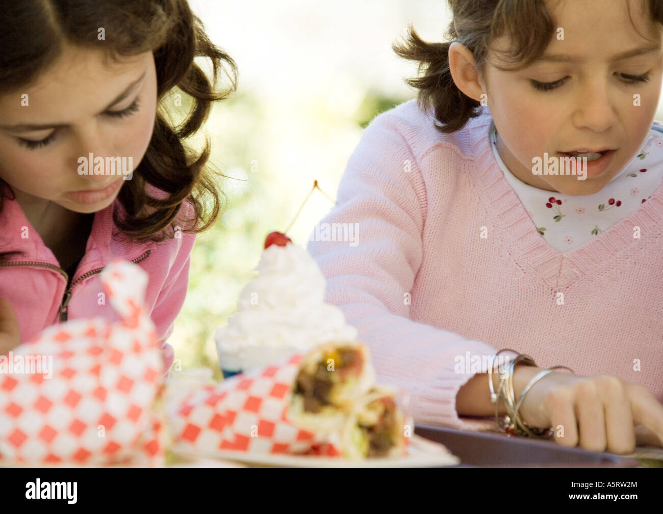Two girls with fast food Stock Photo - Alamy