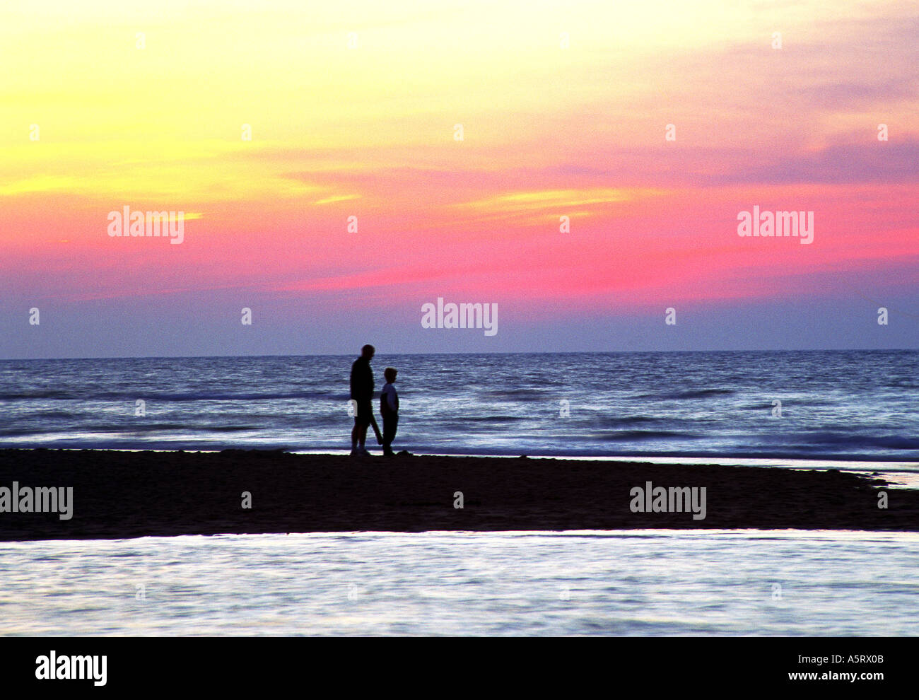 sea sunset with two people silhouetted Stock Photo - Alamy