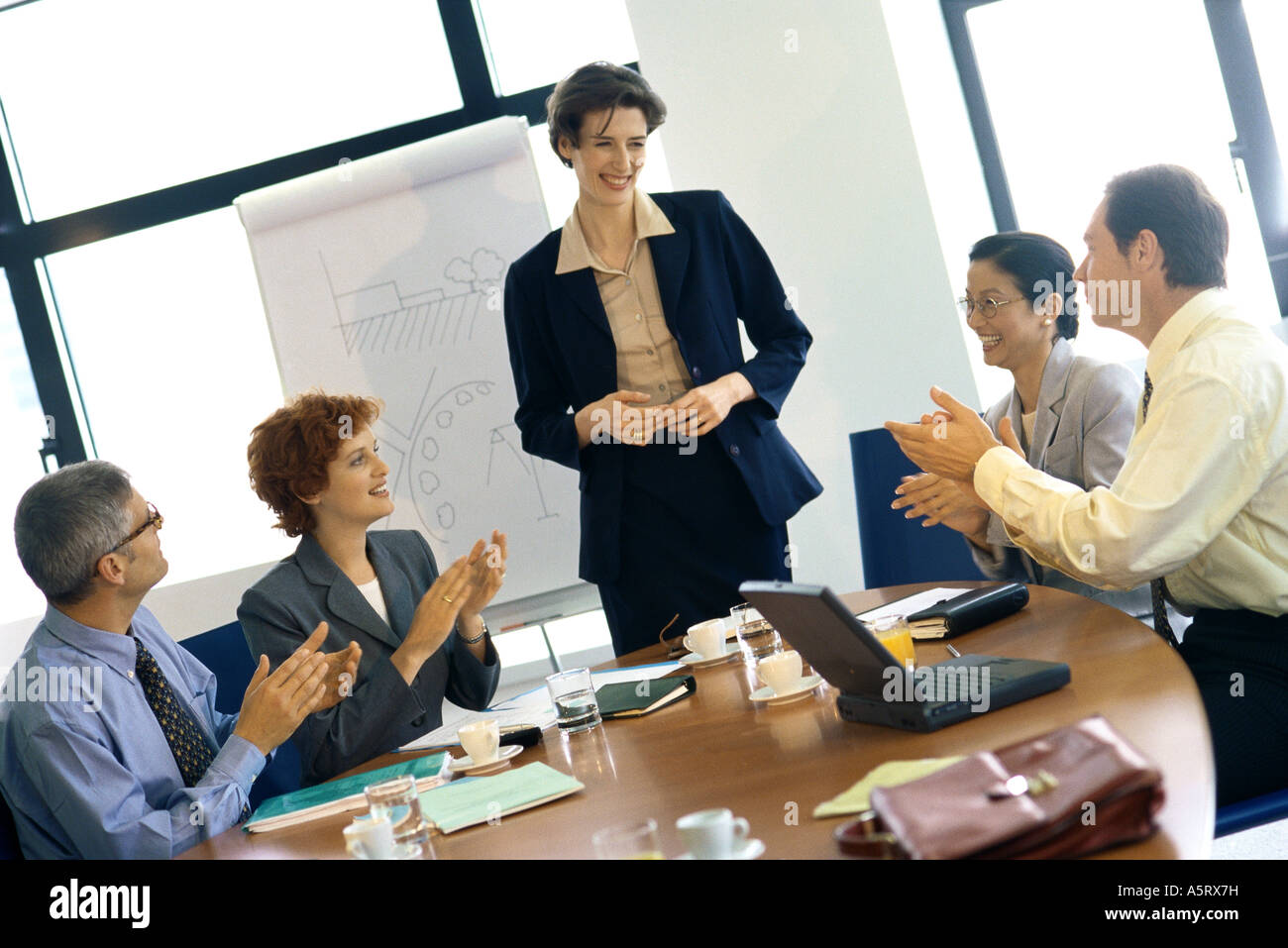 Colleagues clapping for businesswoman after presentation Stock Photo ...