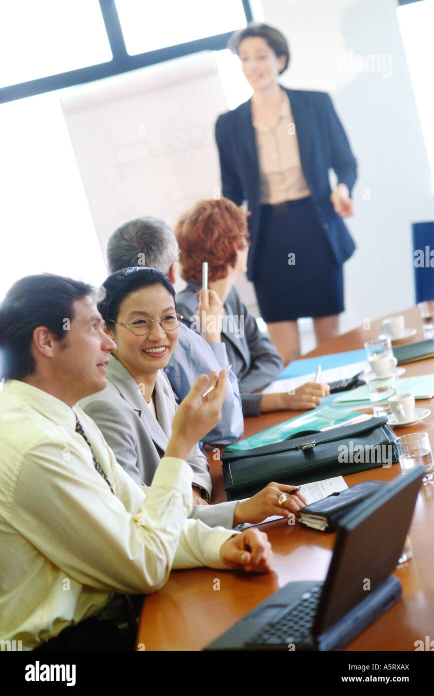 Group of businesspeople sitting around conference table during ...