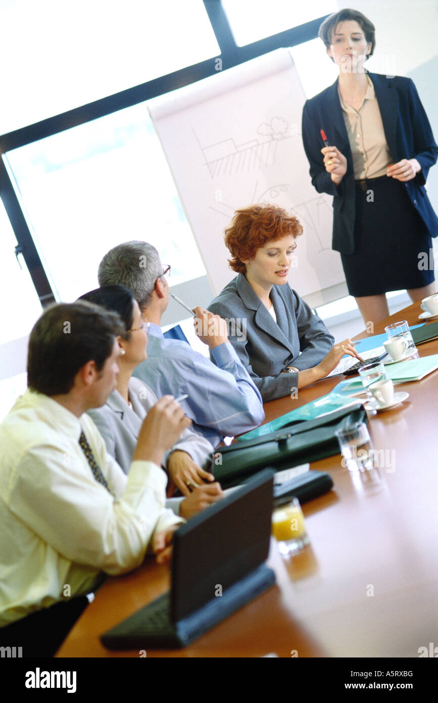 Group of businesspeople sitting around conference table during ...