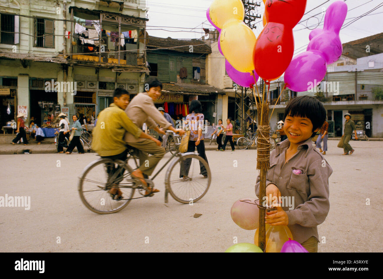 VIETNAM, A YOUNG BOY SELLING BALLOONS ON THE STREET OF HANOI AS THE ...