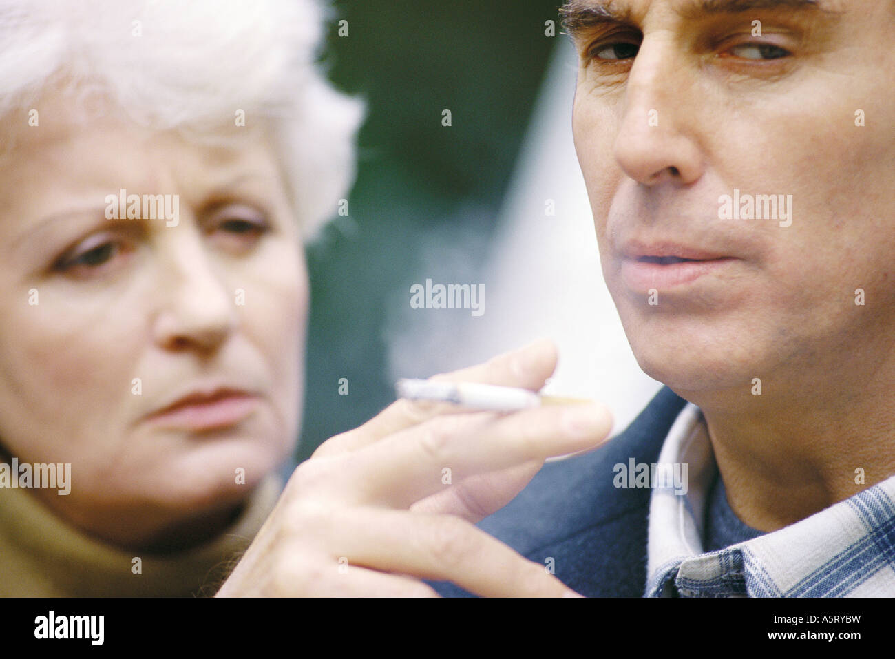 Senior man smoking, wife watching him Stock Photo - Alamy