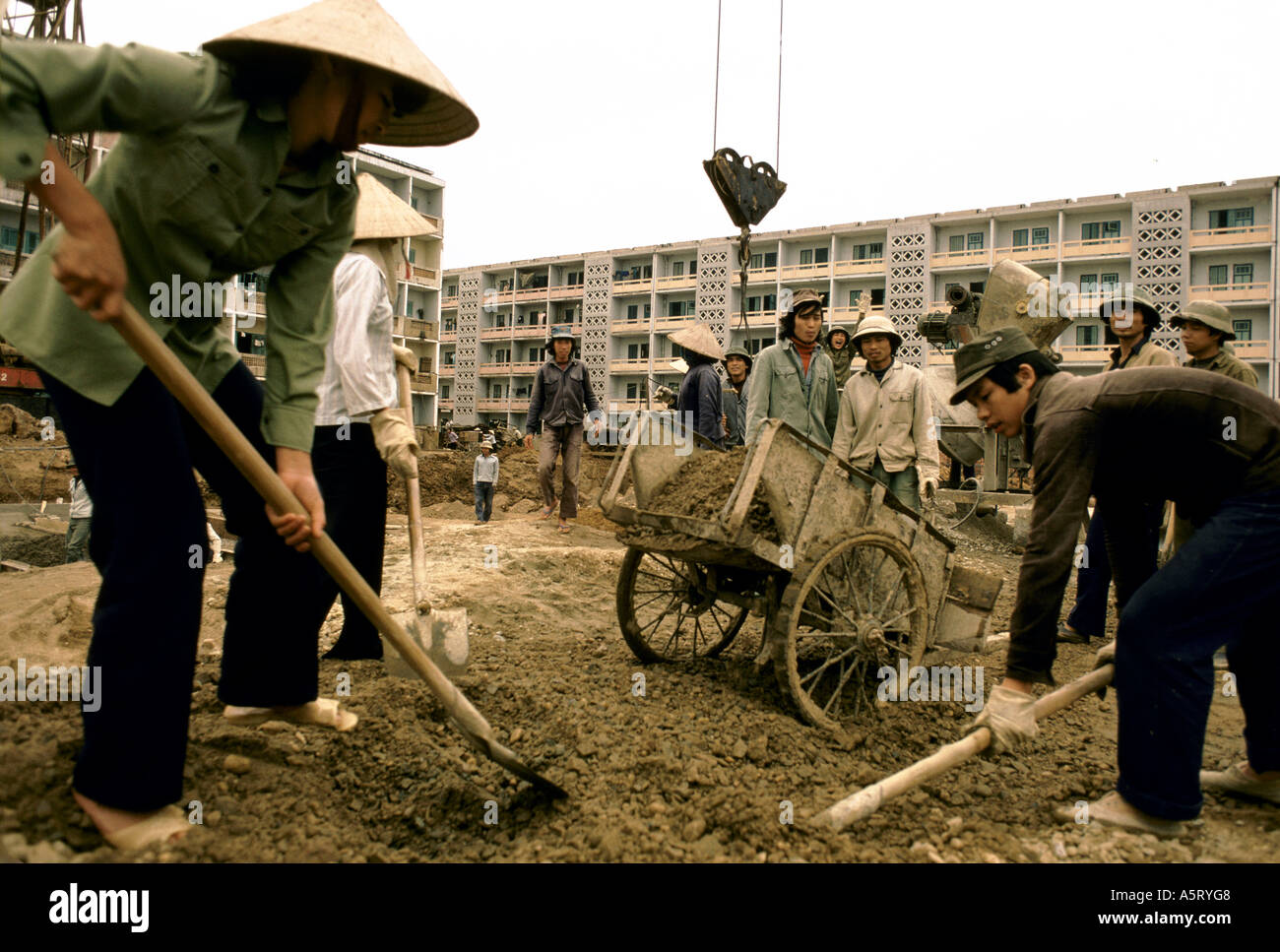 VIETNAM, A FEMALE AND MALE WORKERS DIGGING GROUND IN A CONSTRUCTION ...