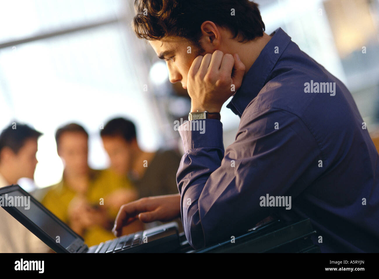 Young man using laptop, side view Stock Photo - Alamy