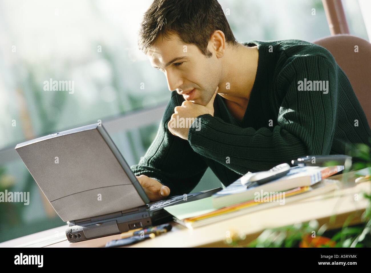 Young man using laptop Stock Photo - Alamy