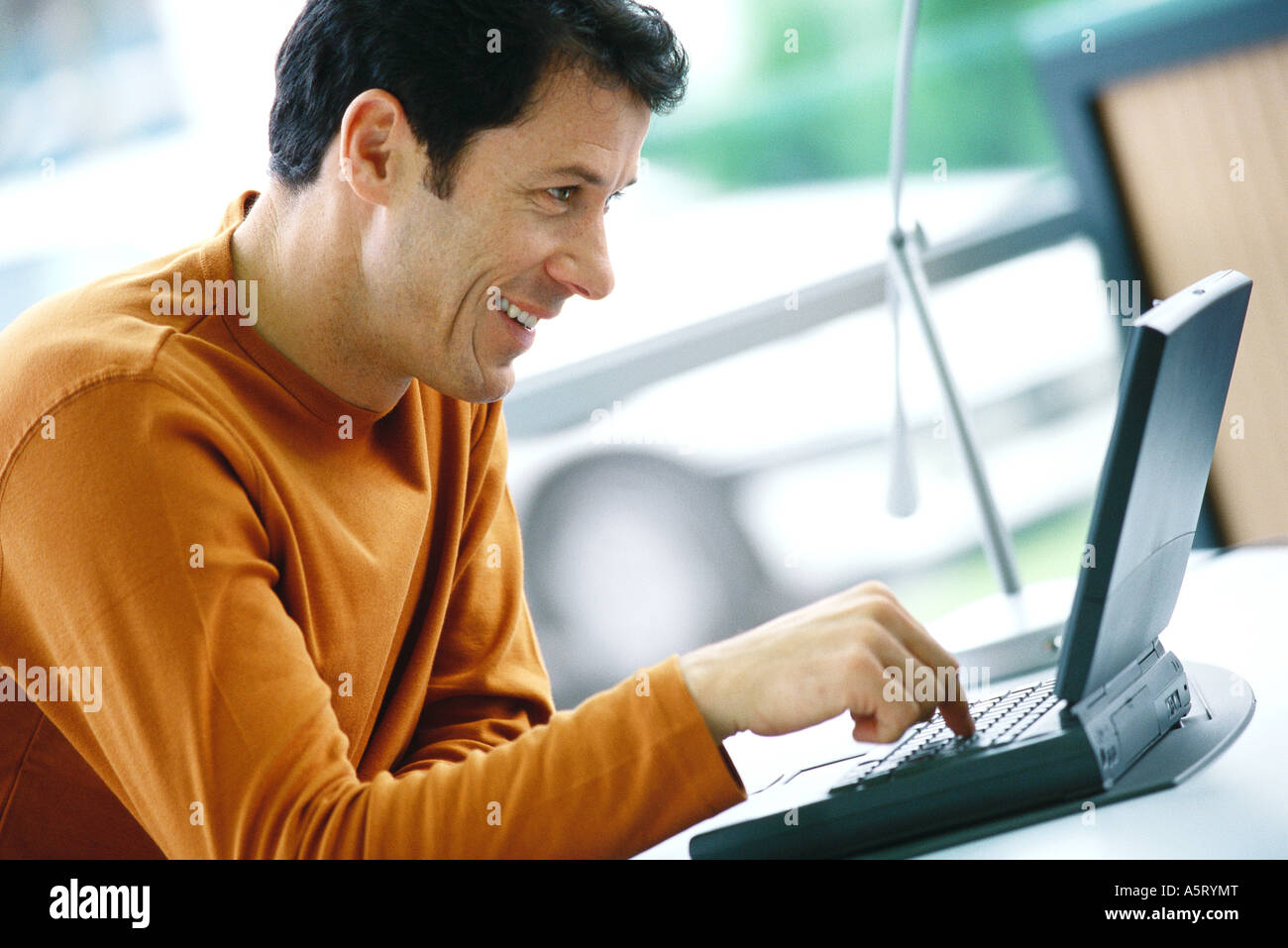 Man using laptop, smiling Stock Photo - Alamy