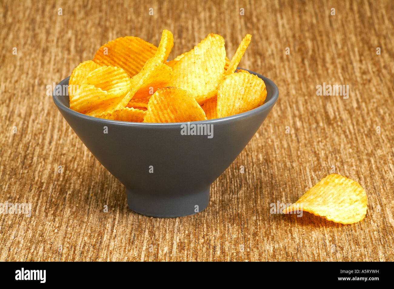 Bowl of crisps on brown cloth Stock Photo - Alamy