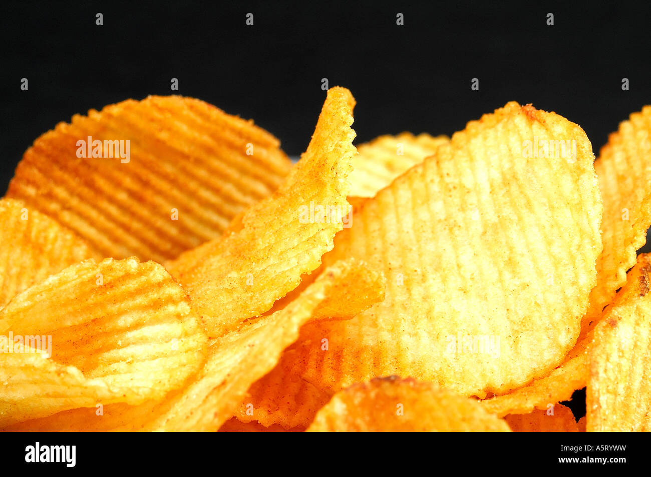 Flakes of crisps on black background Stock Photo - Alamy