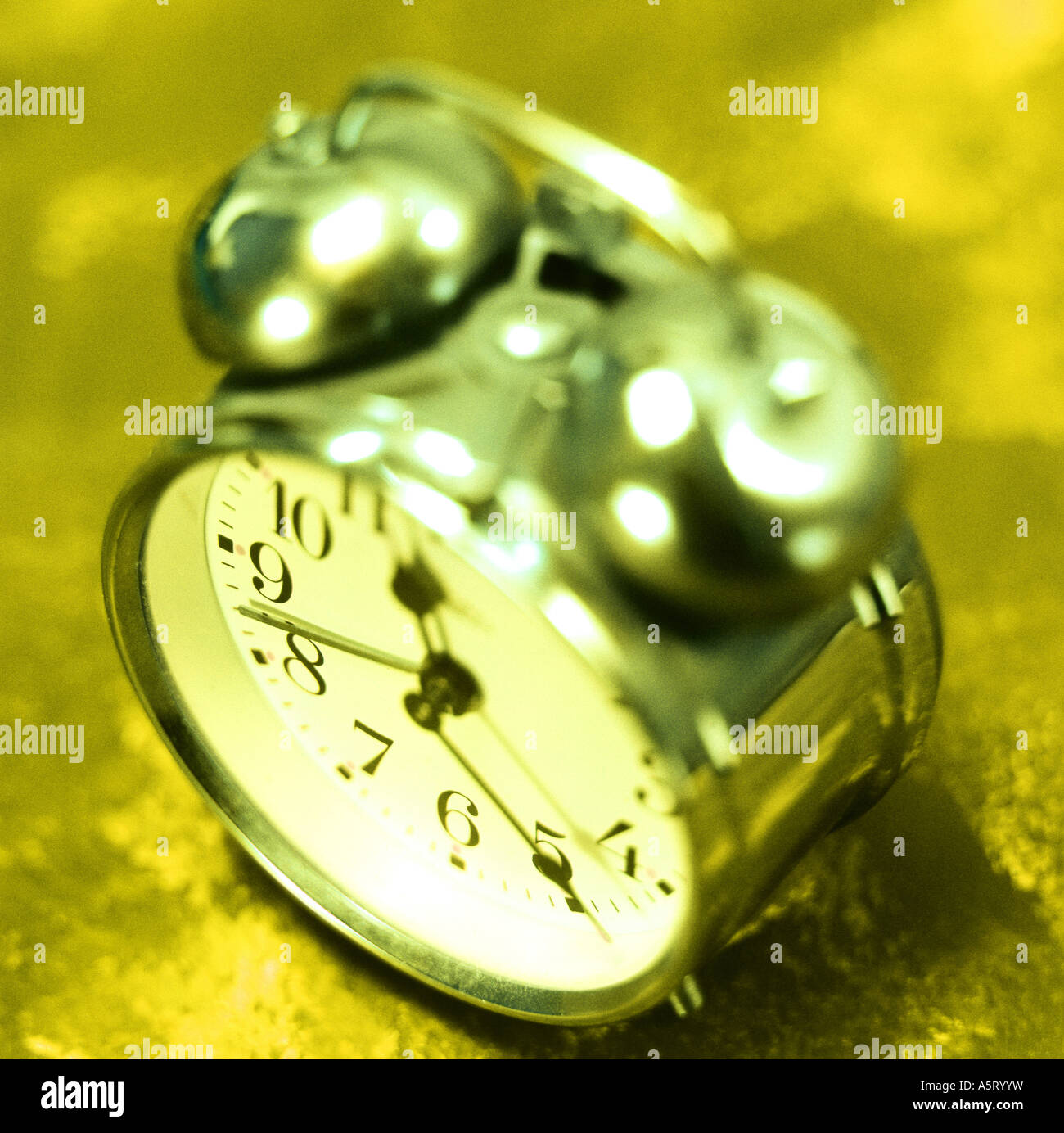 Alarm clock photographed in yellow light Stock Photo - Alamy