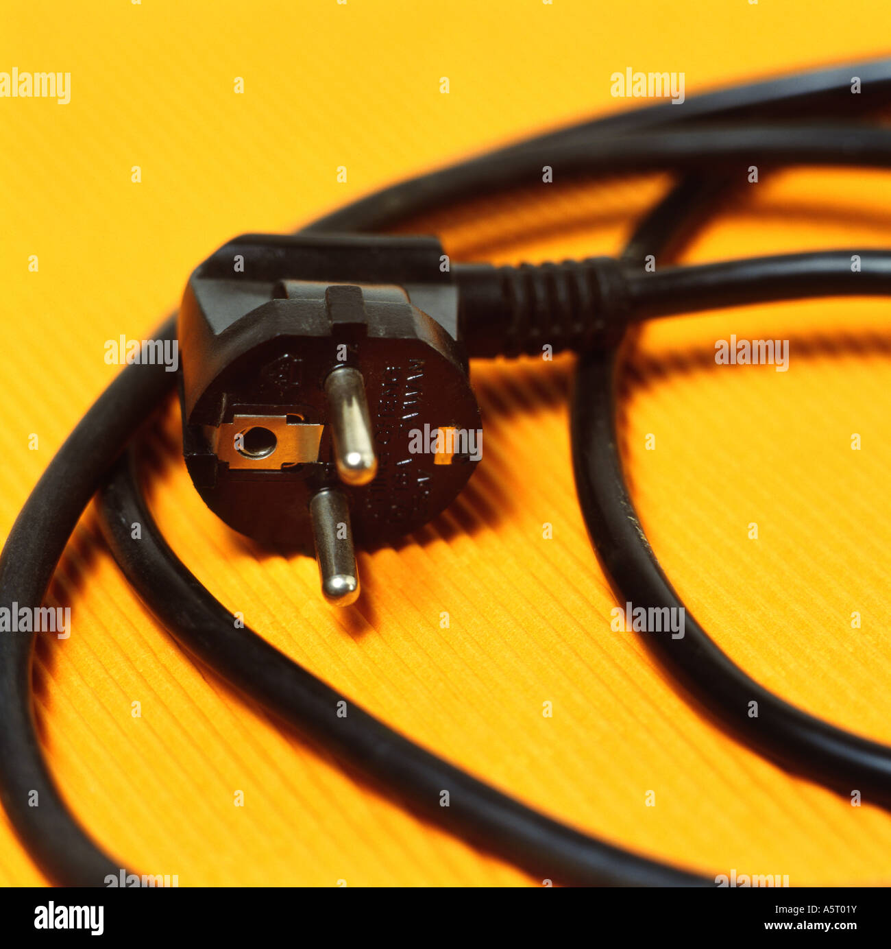 Black plug on orange background Stock Photo - Alamy
