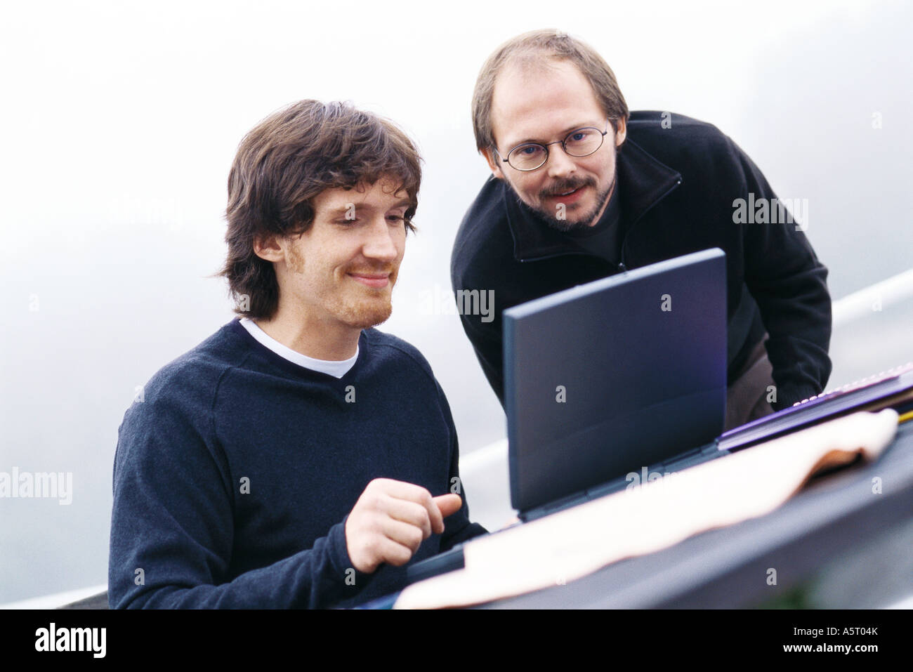 Two men using laptop Stock Photo - Alamy
