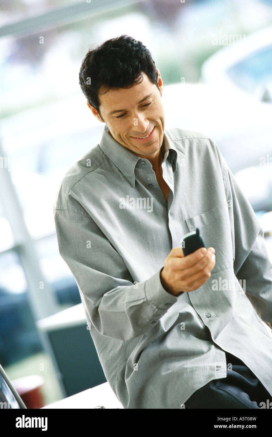 Man using cell phone, smiling Stock Photo - Alamy