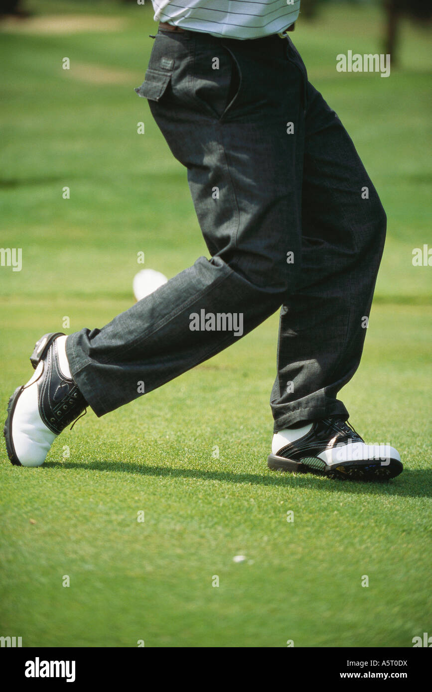 Golfer in mid swing, low section Stock Photo - Alamy